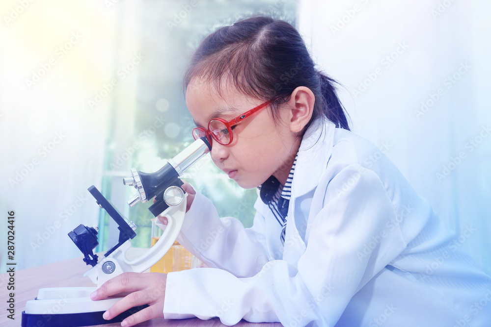 Little asian girl doing experiments in the laboratory. Cool kid ...