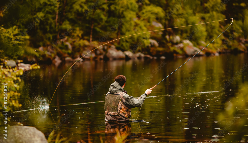 Fisherman using rod fly fishing in mountain river Stock Photo | Adobe Stock