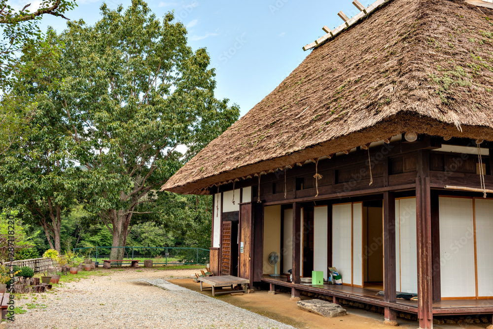 A traditional thatched roof Japanese house preserved at a public park ...