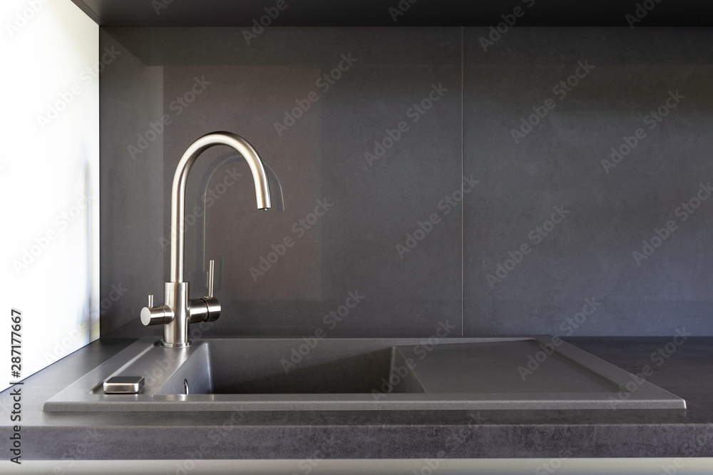 Grey granite kitchen sink with a stainless steel tap for filtered water ...
