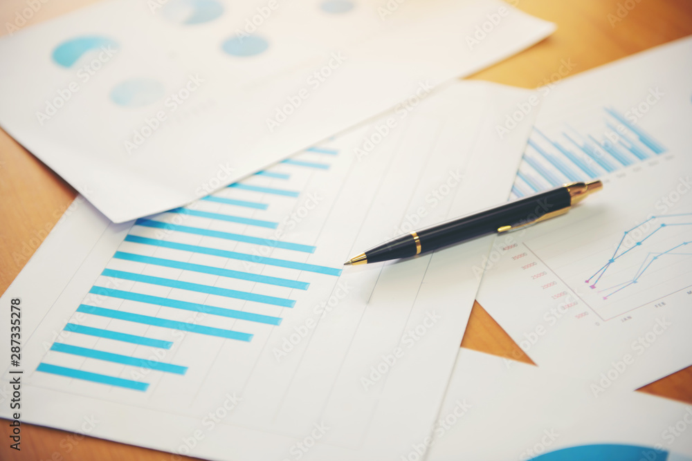 Pen on diagram chart and graphs business report with money, compass ...