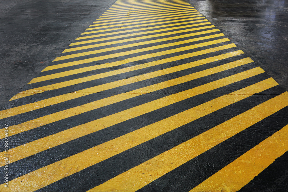 Yellow-black signal strip at the factory. Floor painting for worker ...