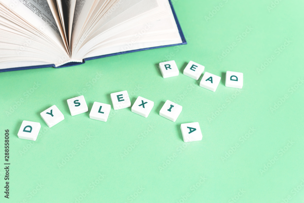 Dyslexia and read words with an open book on trendy pastel mint ...