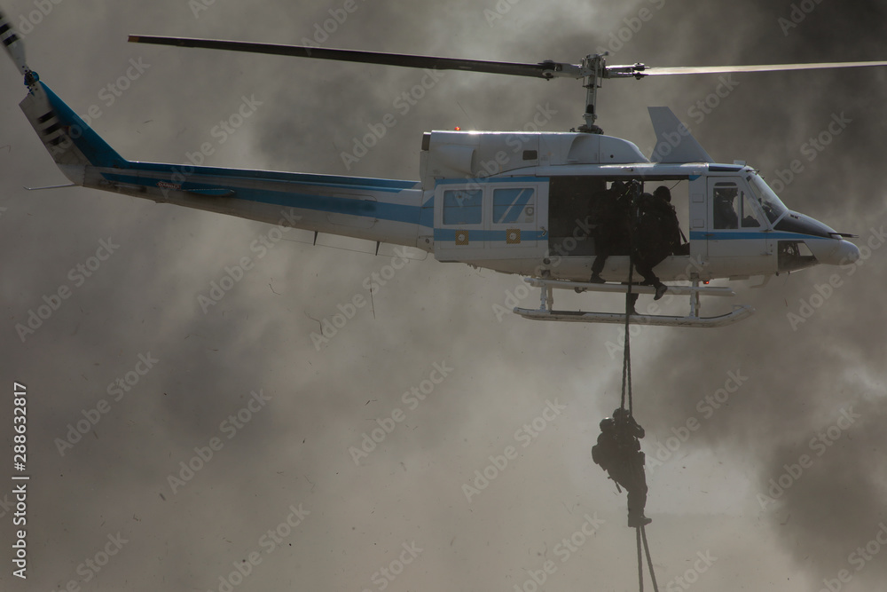 Deploying troops from a military helicopter using fast-roping technique ...