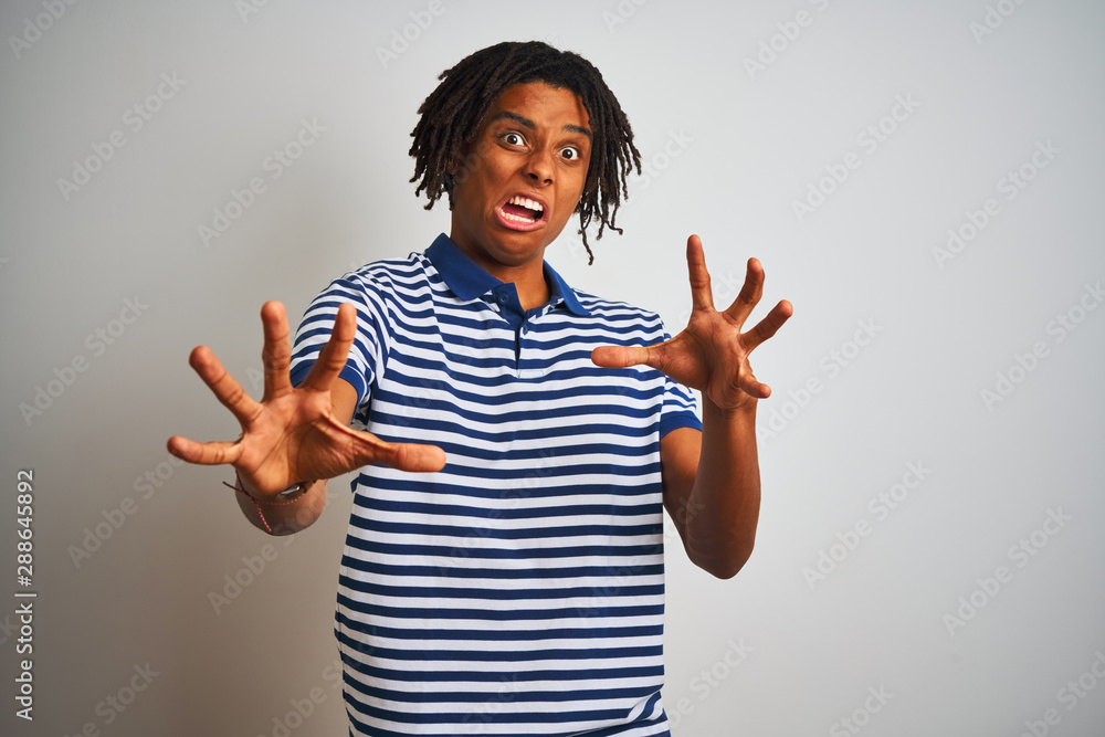 Afro man with dreadlocks wearing striped blue polo standing over ...