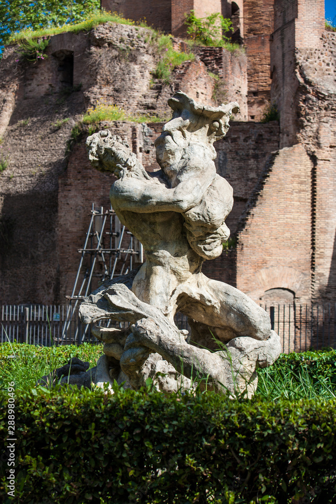 Statue and the ruins of the ancient monumental fountain called Trofei ...