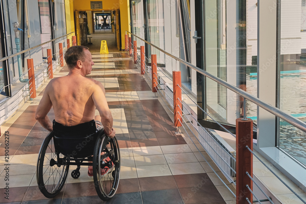 active rehabilitation, man in wheelchair with paralyzed legs on the ...