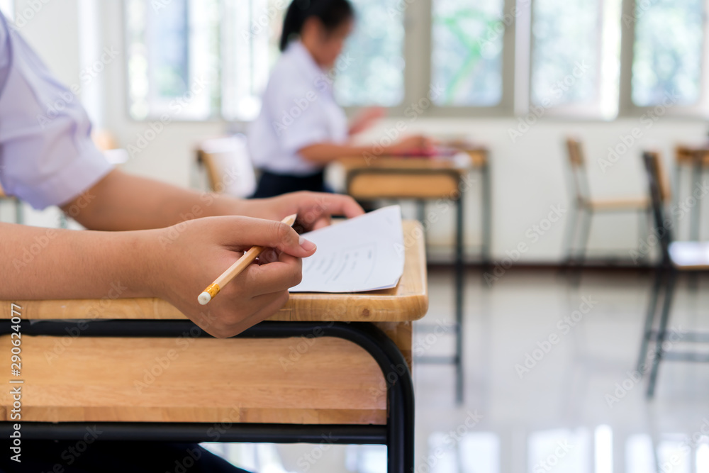 School Students hands taking exams, writing examination holding pencil ...