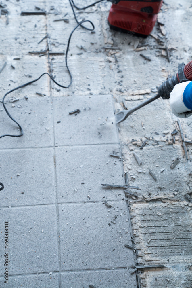 construction worker using a handheld demolition hammer and wall breaker ...