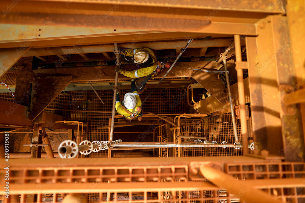 Top view of scaffolders wearing safety helmet, fall arrest harness ...