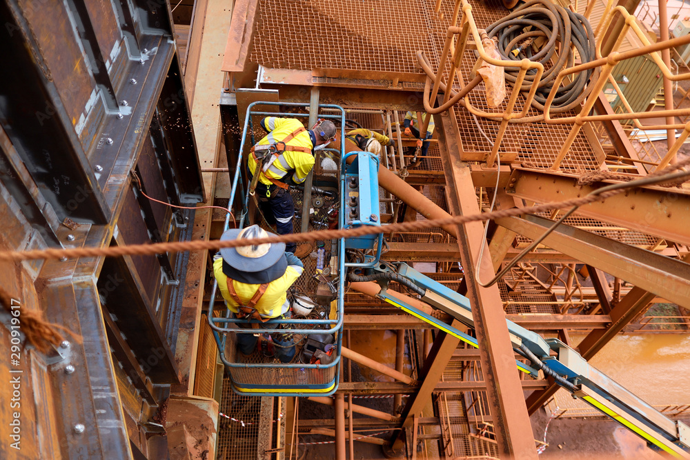 Maintenance welder on Elevating Work Platform wearing fall arrest ...