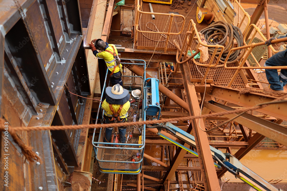 Maintenance welder on Elevating Work Platform wearing fall arrest ...