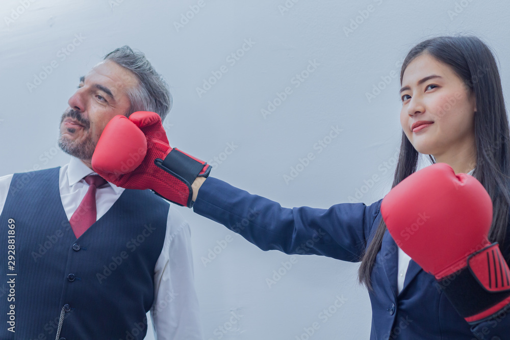 business woman wearing a suit, wearing a red boxing glove, punching the ...