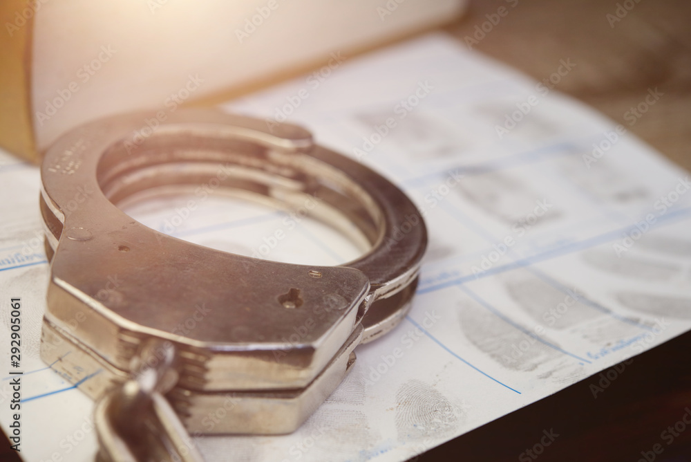 Crime and violence concept.Police Handcuffs on fingerprints crime page ...