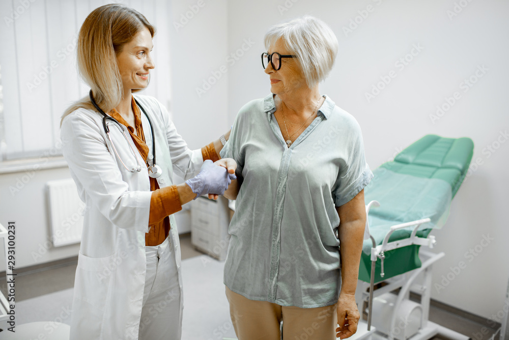 Gynecologist taking care of a senior woman patient, supporting and ...