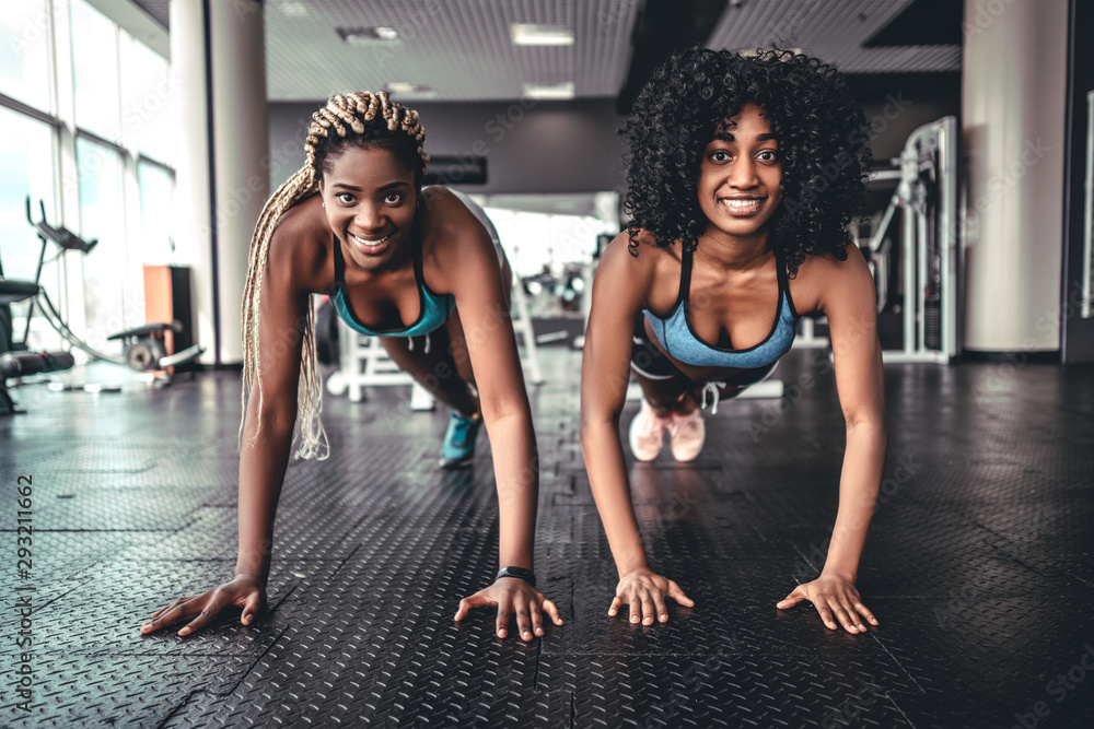 Fit girls in gym doing plank exercise for back spine and posture ...