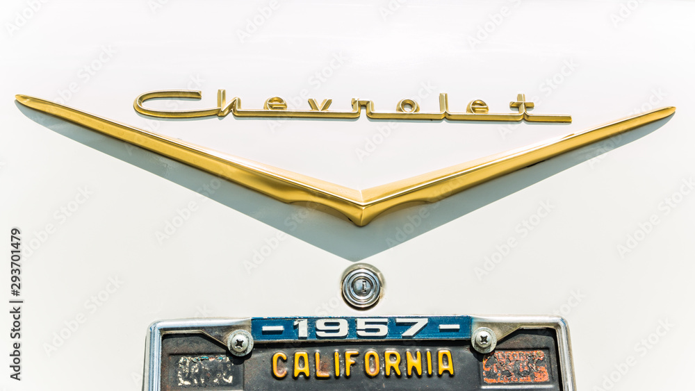 The rear trunk nameplate on a white 1957 Chevrolet with gold trim and a ...