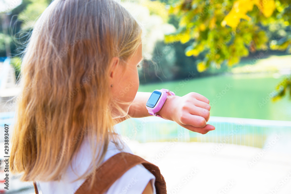 Modern technology for children. School girl using her GPS smart watch ...