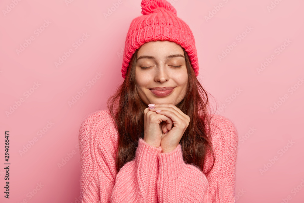 Portrait of good looking charming woman keeps both hands under chin ...