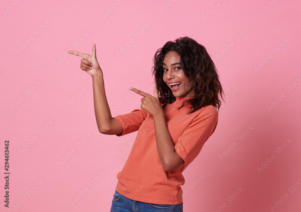 Happy young african woman standing with her finger pointing isolated ...