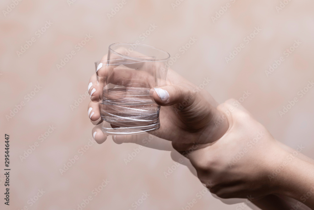 Trembling hand holding glass with alcohol drink Stock Photo | Adobe Stock
