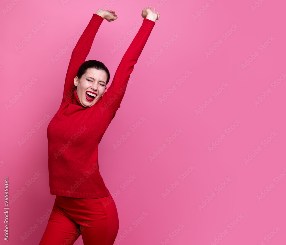 girl in red sweater posing on pink studio background. positive emotions ...