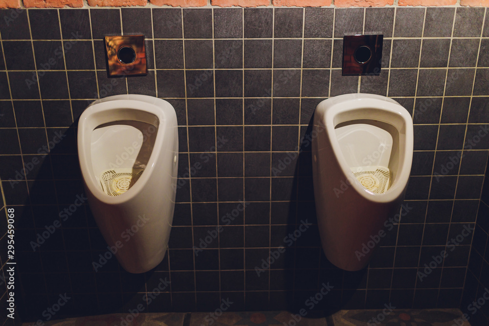 White urinals in men's bathroom. Modern restroom interior with urinals ...