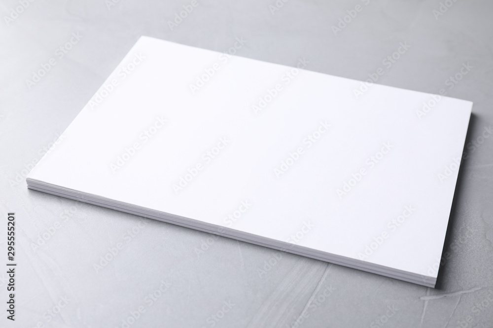 Blank paper sheets on light grey stone background. Mock up for design ...