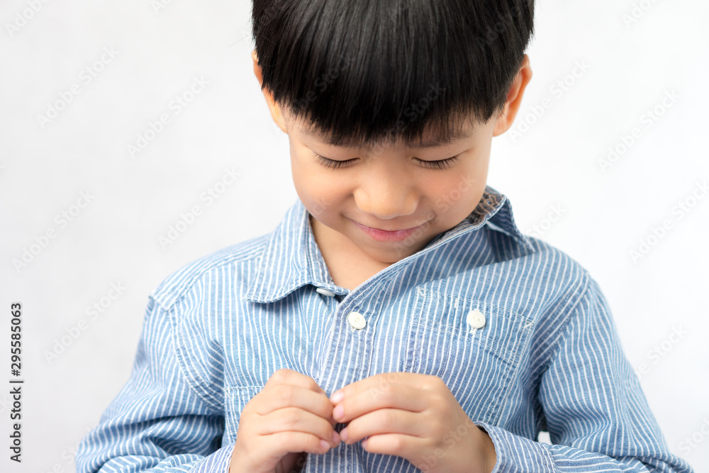 An adorable little asian boy has mistakenly buttoned up wrong, he ...