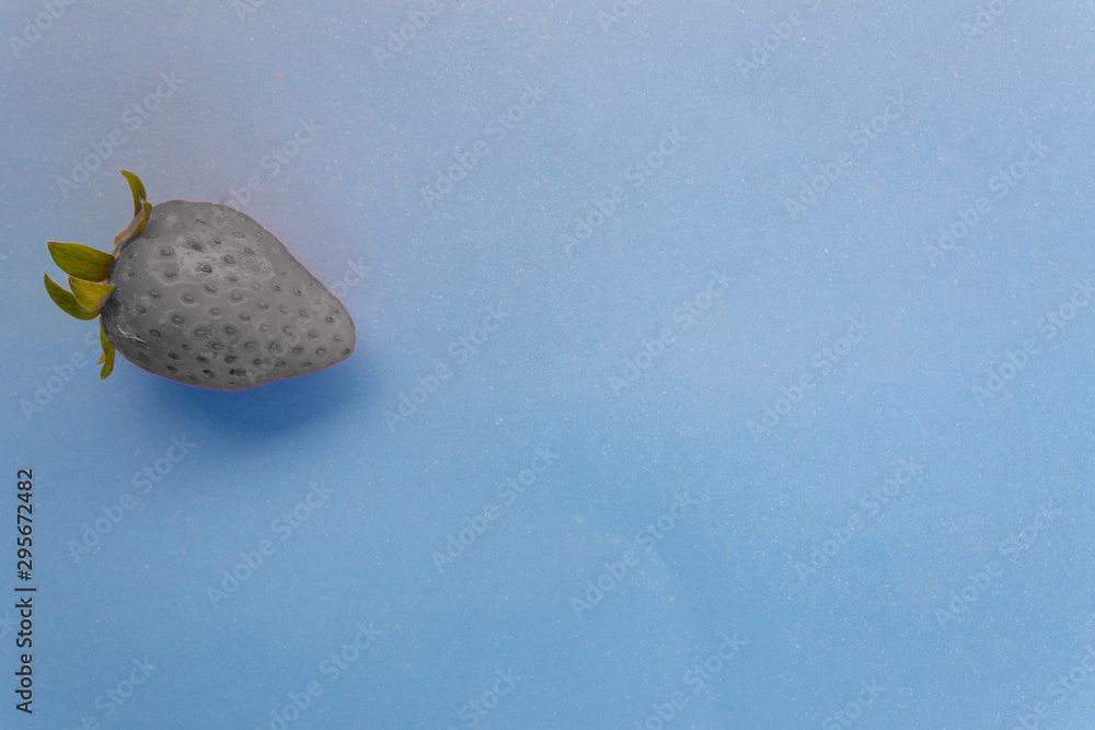 Strawberry of blue color on blue background with green leaves. Creative ...