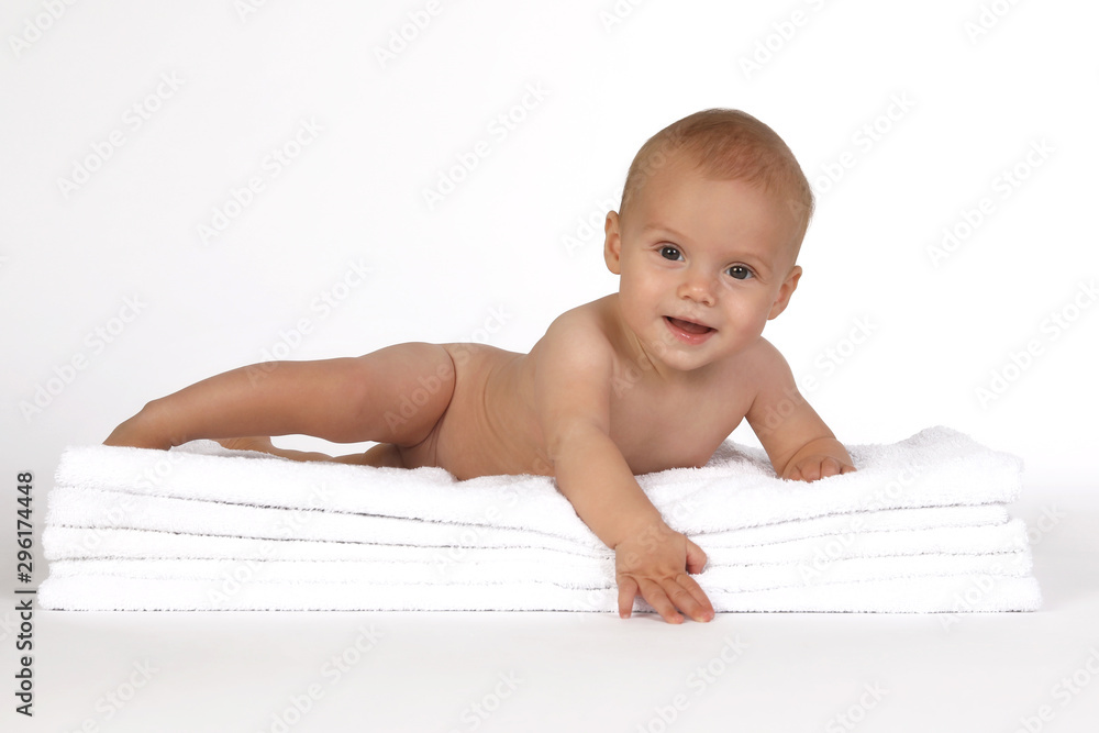 Photo Stock Kleines nacktes Baby liegt auf einem Handtuchstapel und ...
