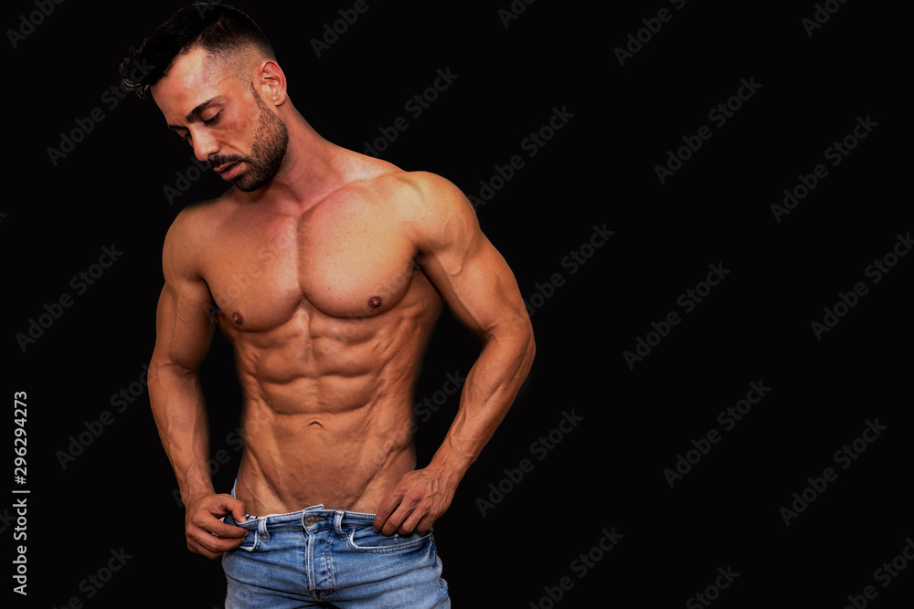 Very muscular fitness model man, posing dressed in jeans and no shirt ...