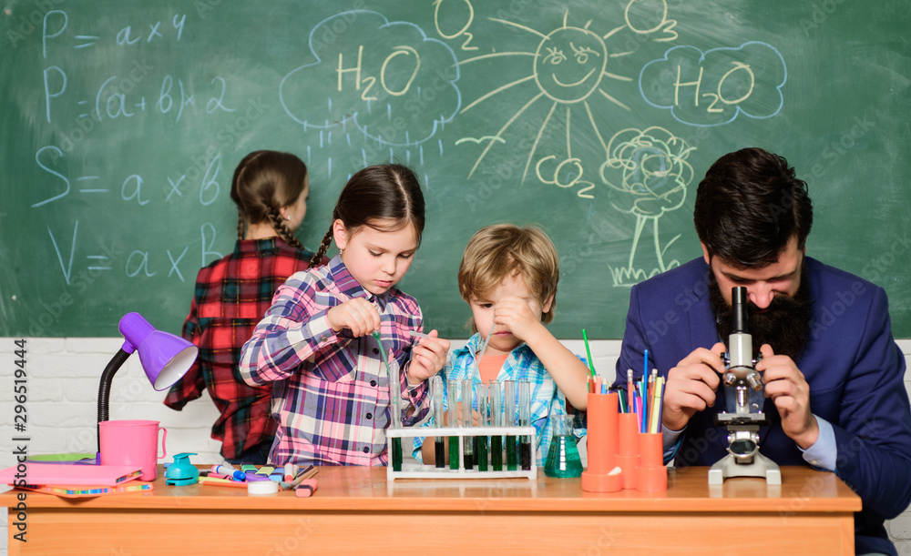 Fascinating chemistry lesson. Man bearded teacher and pupils with test ...