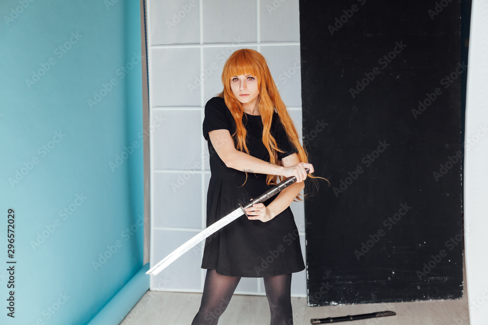 Woman cosplayer anime with red hair holds a Japanese sword Stock Photo ...