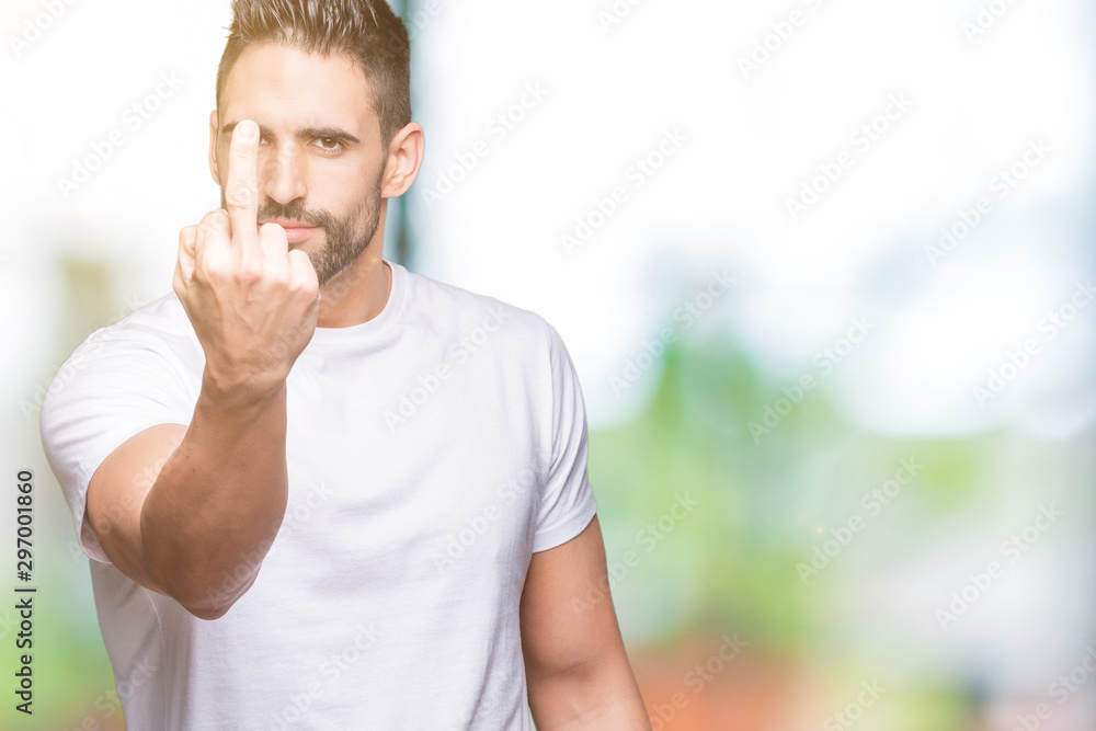 Handsome man wearing white t-shirt over outdoors background Showing ...