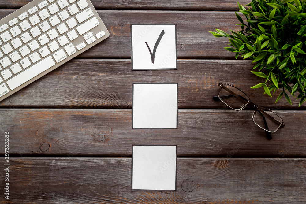 Check mark in check-box of check list on dark wooden office background ...