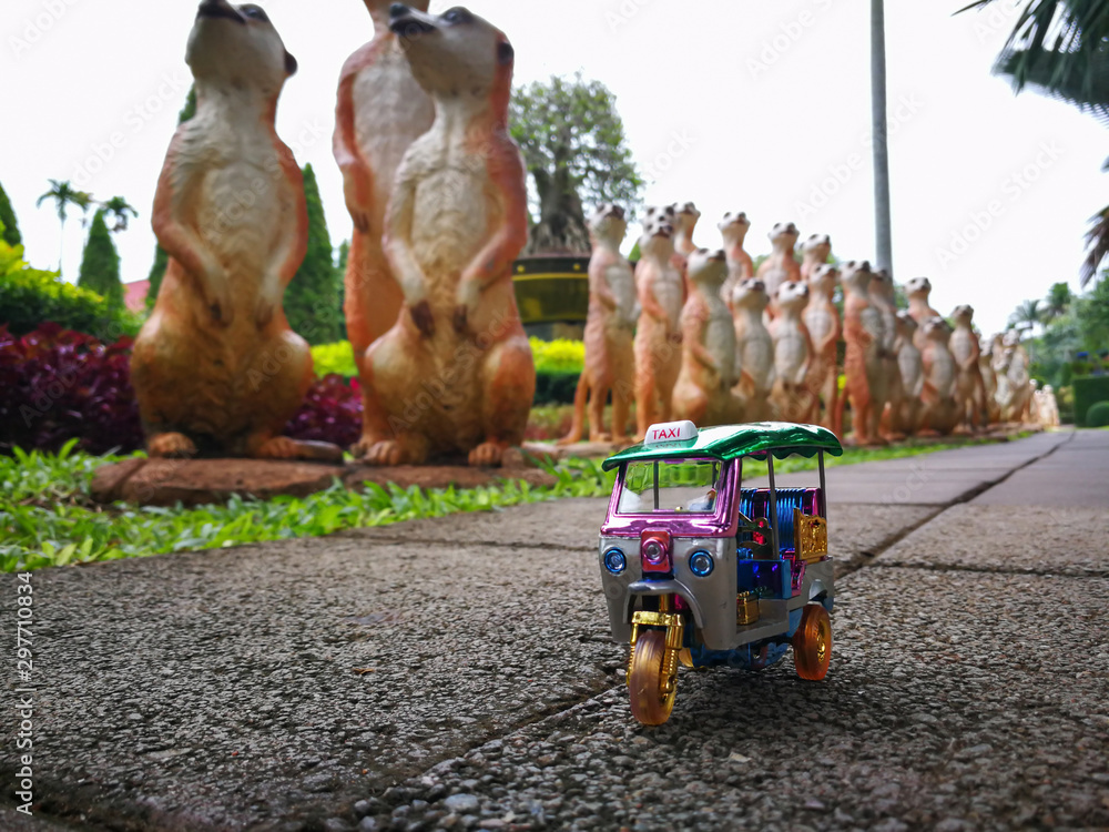 Souvenir mini tuk tuk on Black surface table or road and blur park for ...