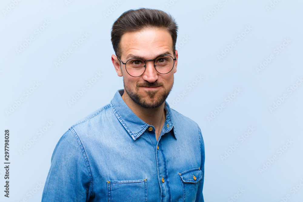 young handsome man with a goofy, crazy, surprised expression, puffing ...