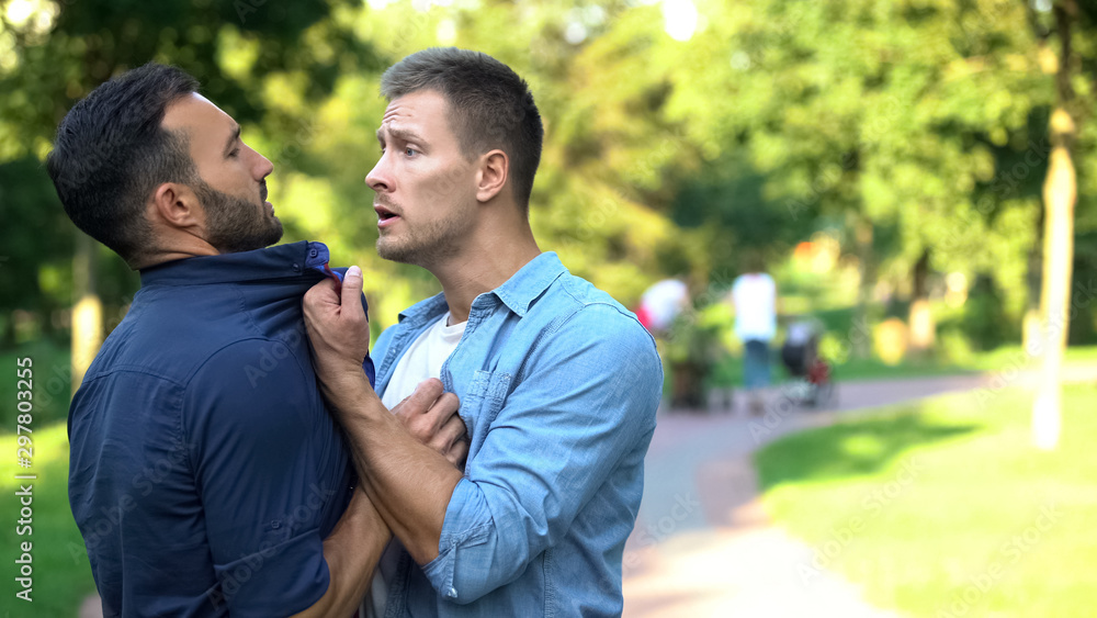Angry man pushing threatening male outdoors solving problem force ...