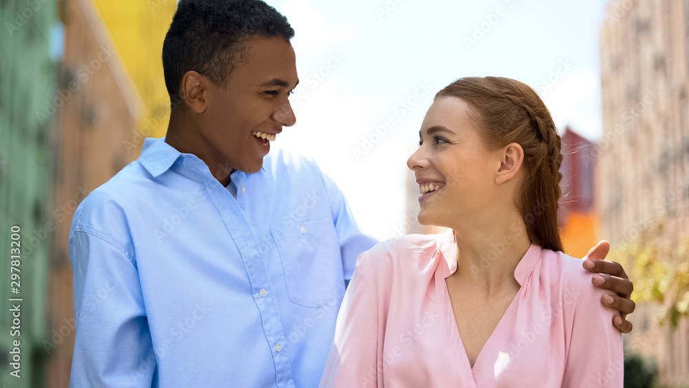 Girlfriend and boyfriend looking at each other and laughing happy to be ...