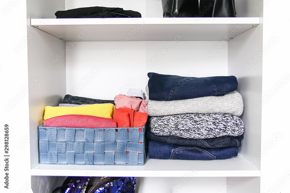 Different clothes in home wardrobe. Small space organization. Vertical ...
