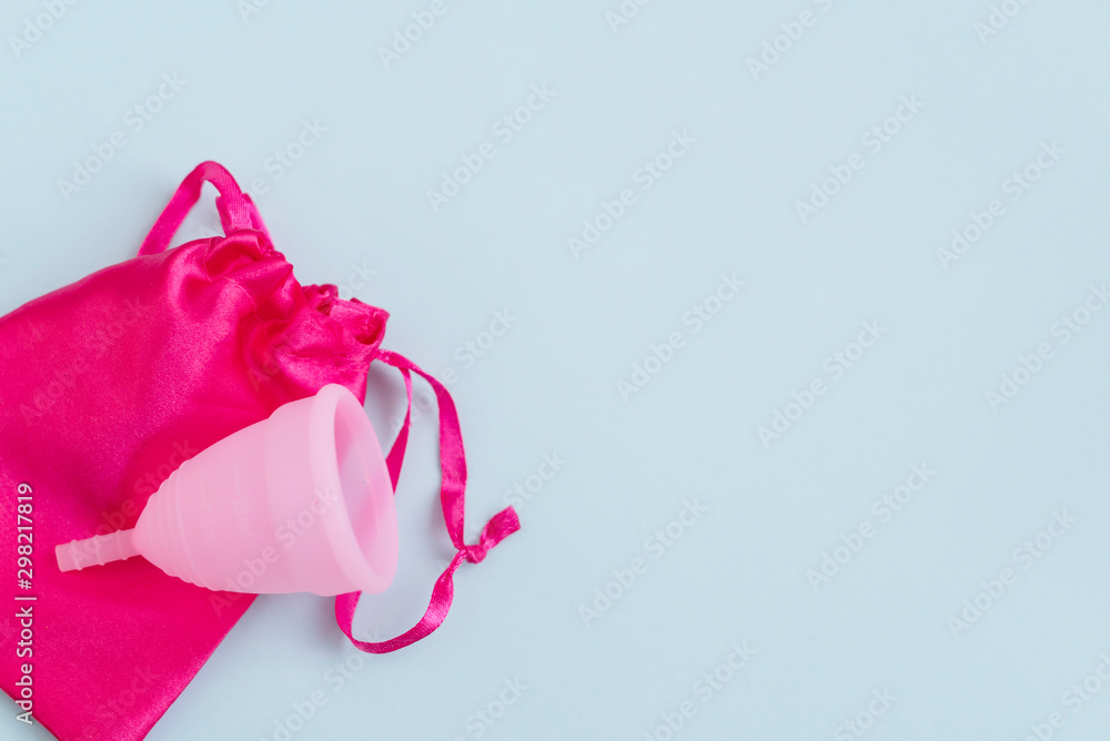 pink menstrual Cup and bag on blue background. woman period concept ...
