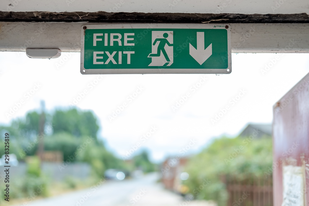 Shallow focus, isolated image of a green Fire Exit sign seen attached ...