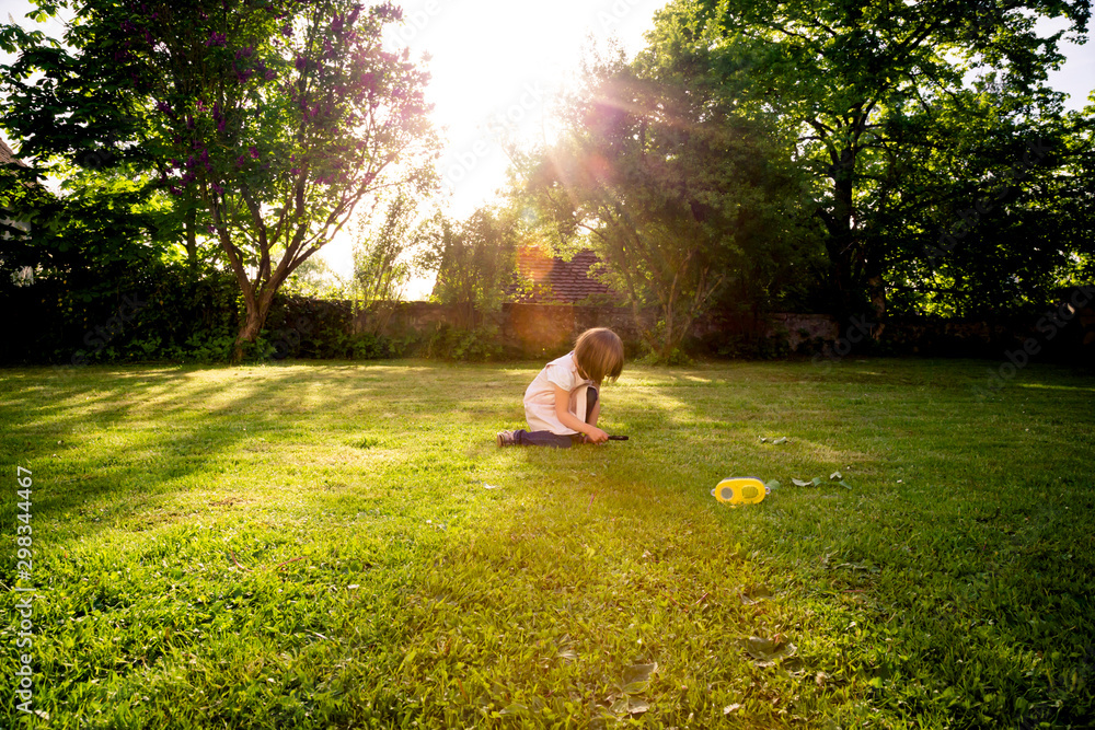 Little girl crouching on a meadow using magnifying glass Stock Photo ...