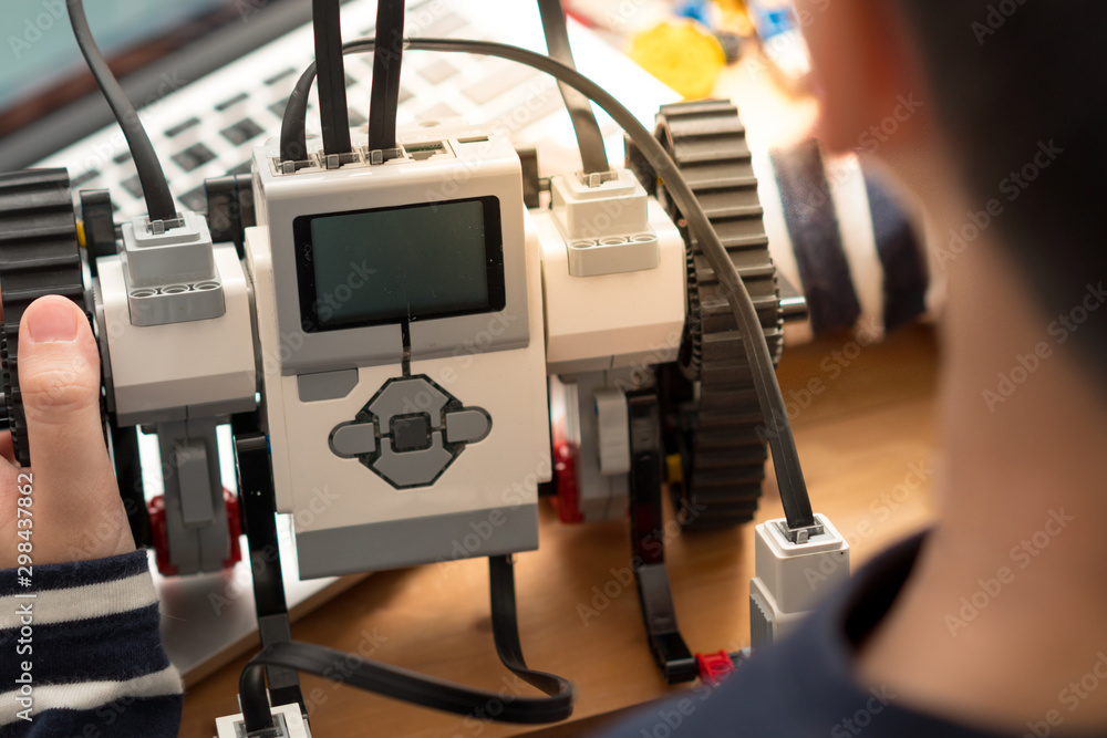 Closeup : hands of preteen / teenage boy codes blocks Mindstorms on his ...