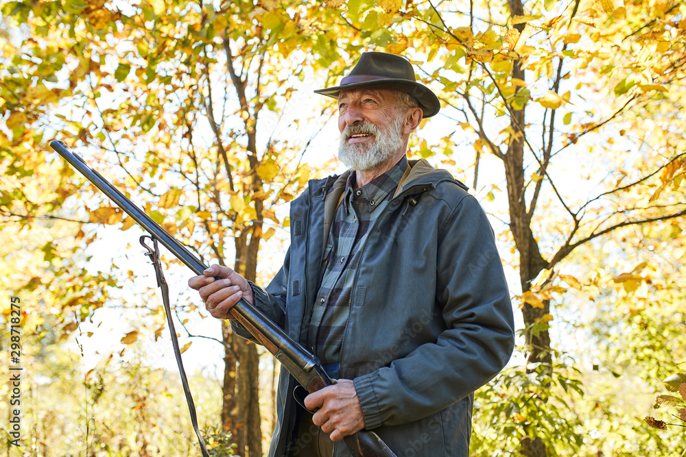Senior caucasian hunter holding shotgun ready to shoot on wild animals ...