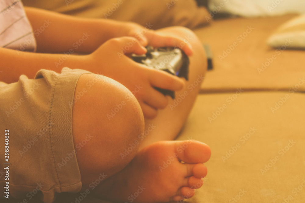 Hands with video game control, feet crossed Stock Photo | Adobe Stock