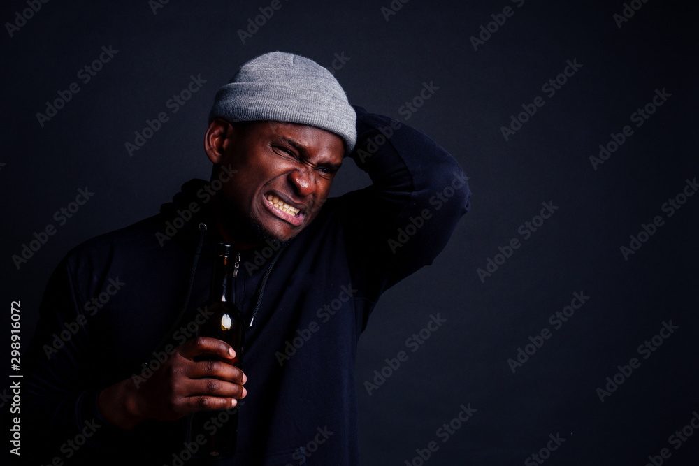 african american man holding a bottle of wine and feeling headache shit ...