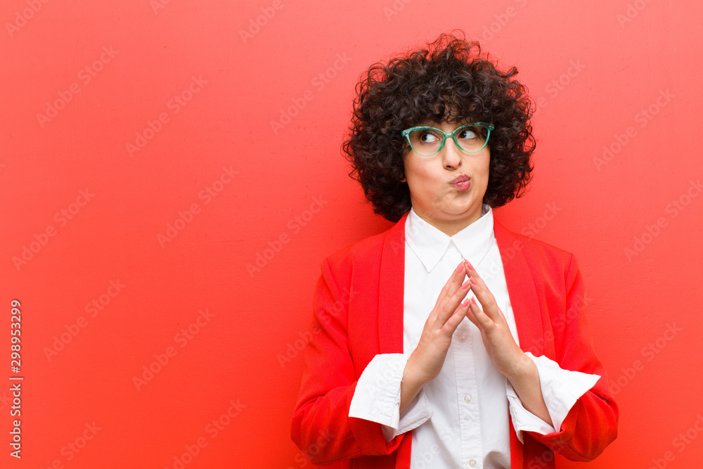 young pretty afro woman scheming and conspiring, thinking devious ...