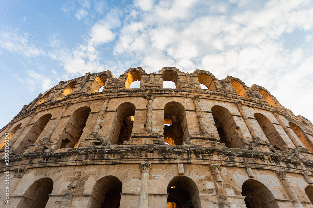 Amphitheater in El Djem from outside. Completed part with arches of ...